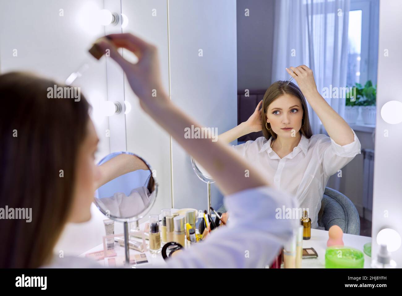 Young woman treating her hair using medical drops Stock Photo - Alamy