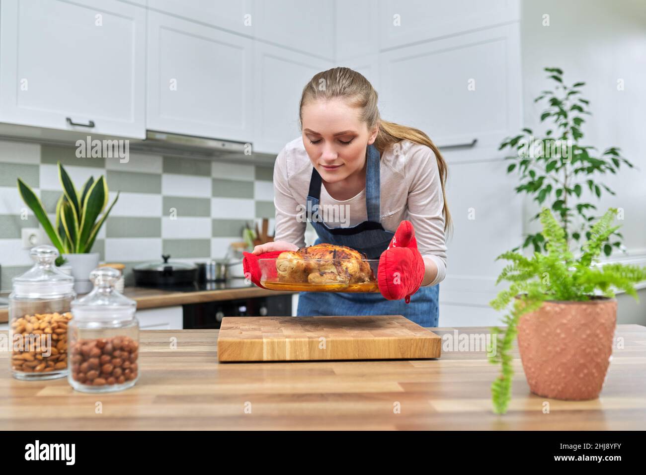 Woman cooking baked chicken at home in the kitchen Stock Photo - Alamy