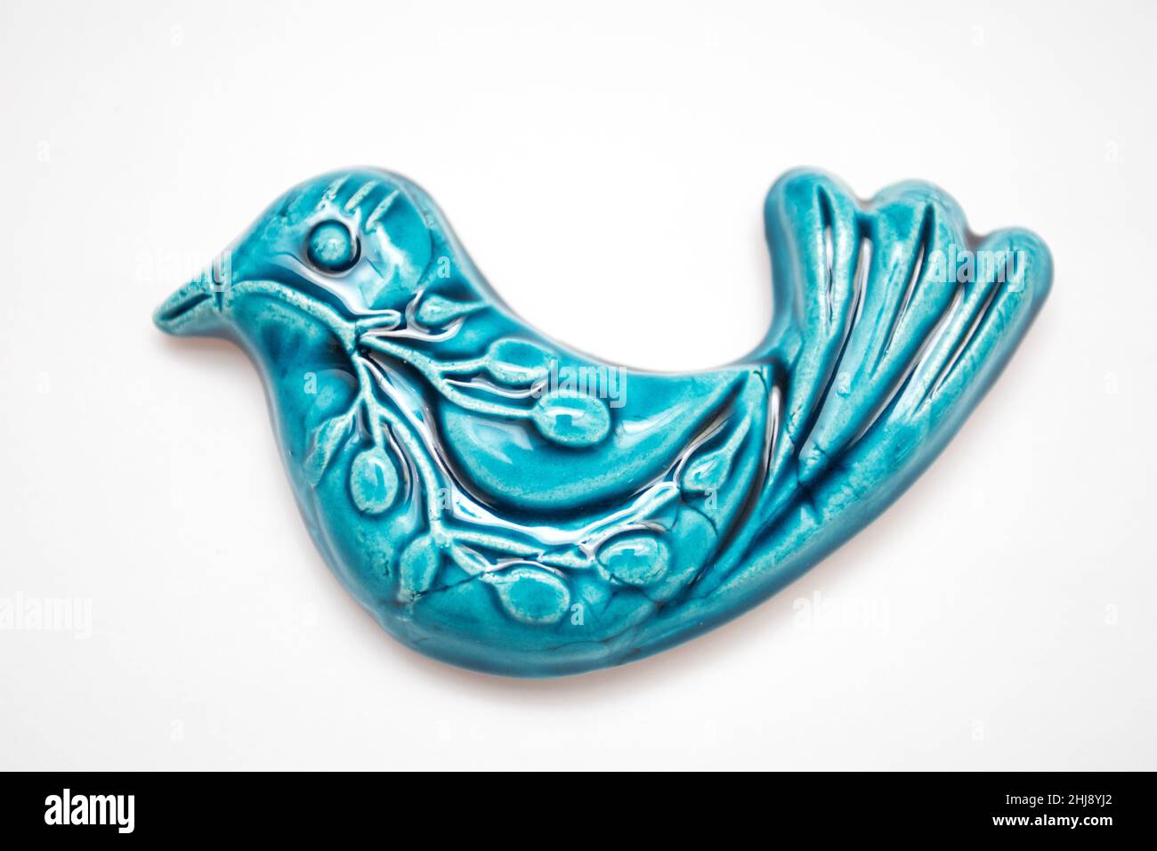 A figurine of a blue ceramic bird. The blue bird is a symbol of ...