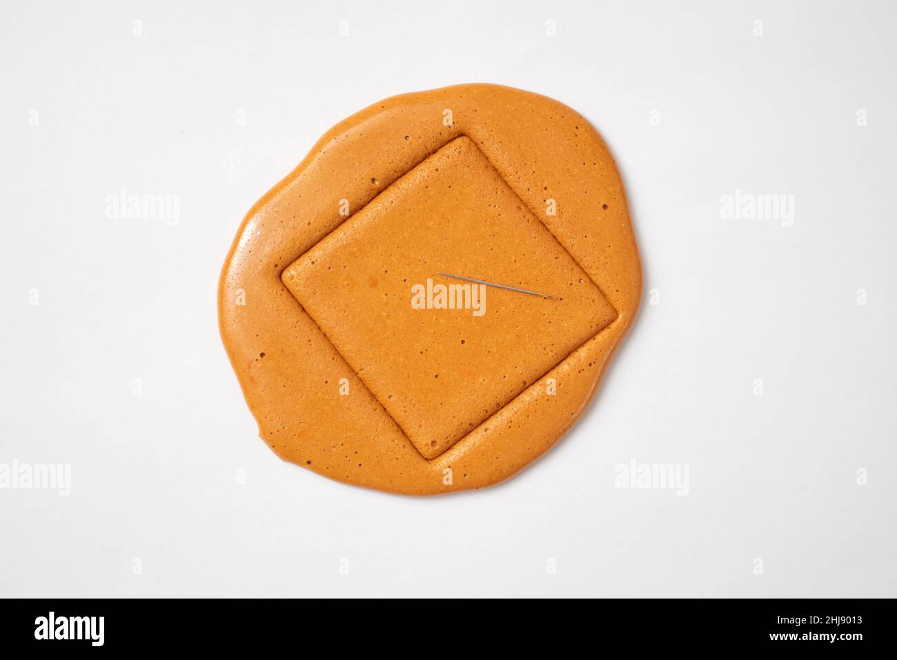 Korean Dalgona sugar candy cookie with a metal needle Stock Photo - Alamy
