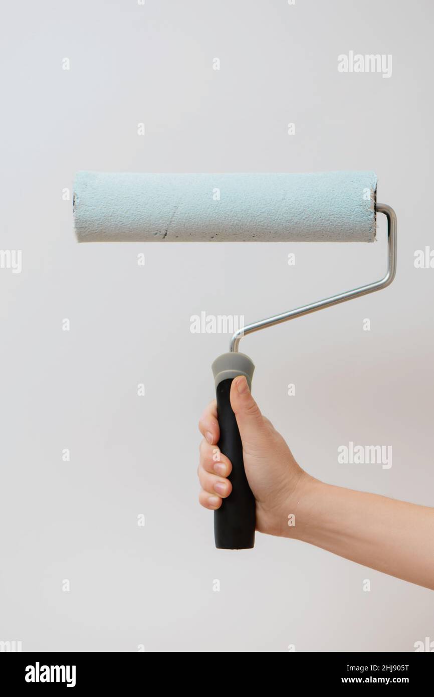 Hand holding paint roller isolated on white background Stock Photo - Alamy