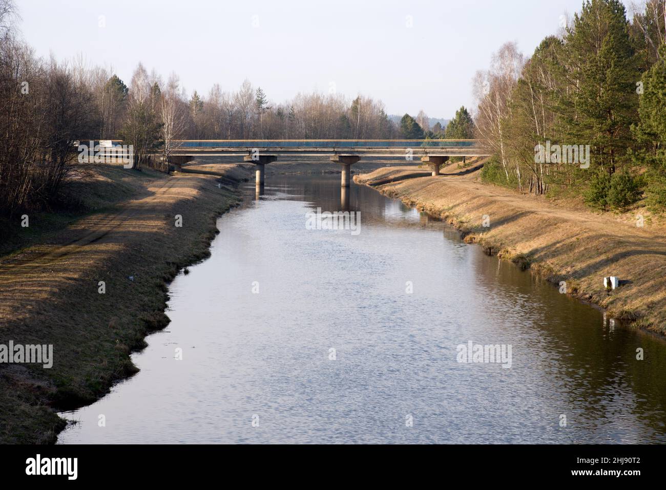 View of a small river with a bridge in spring. Channel of the Vileyka ...