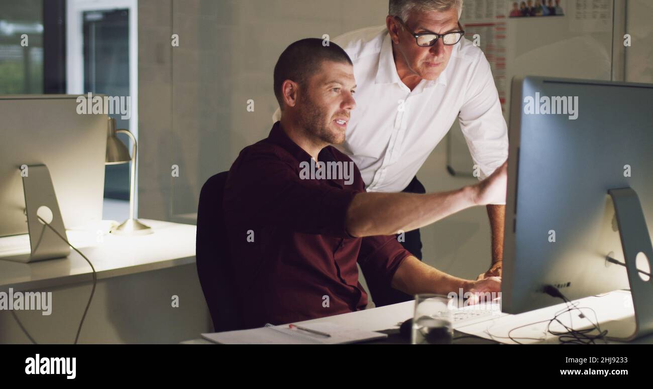 Getting some advice. Cropped shot of two businessmen working together ...