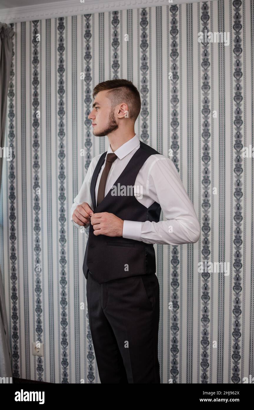 A man straightens his tie, buttons his jacket, straightens his shirt ...