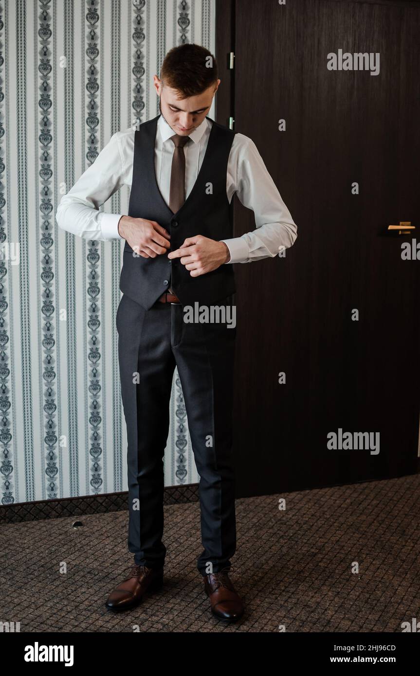 A man straightens his tie, buttons his jacket, straightens his shirt ...