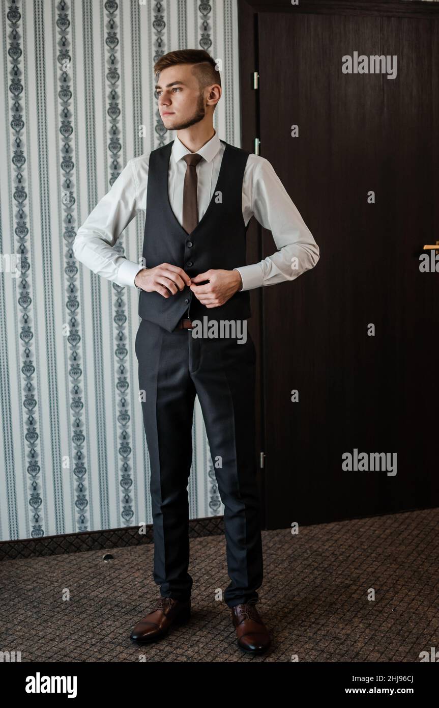 A Man Straightens His Tie Buttons His Jacket Straightens His Shirt