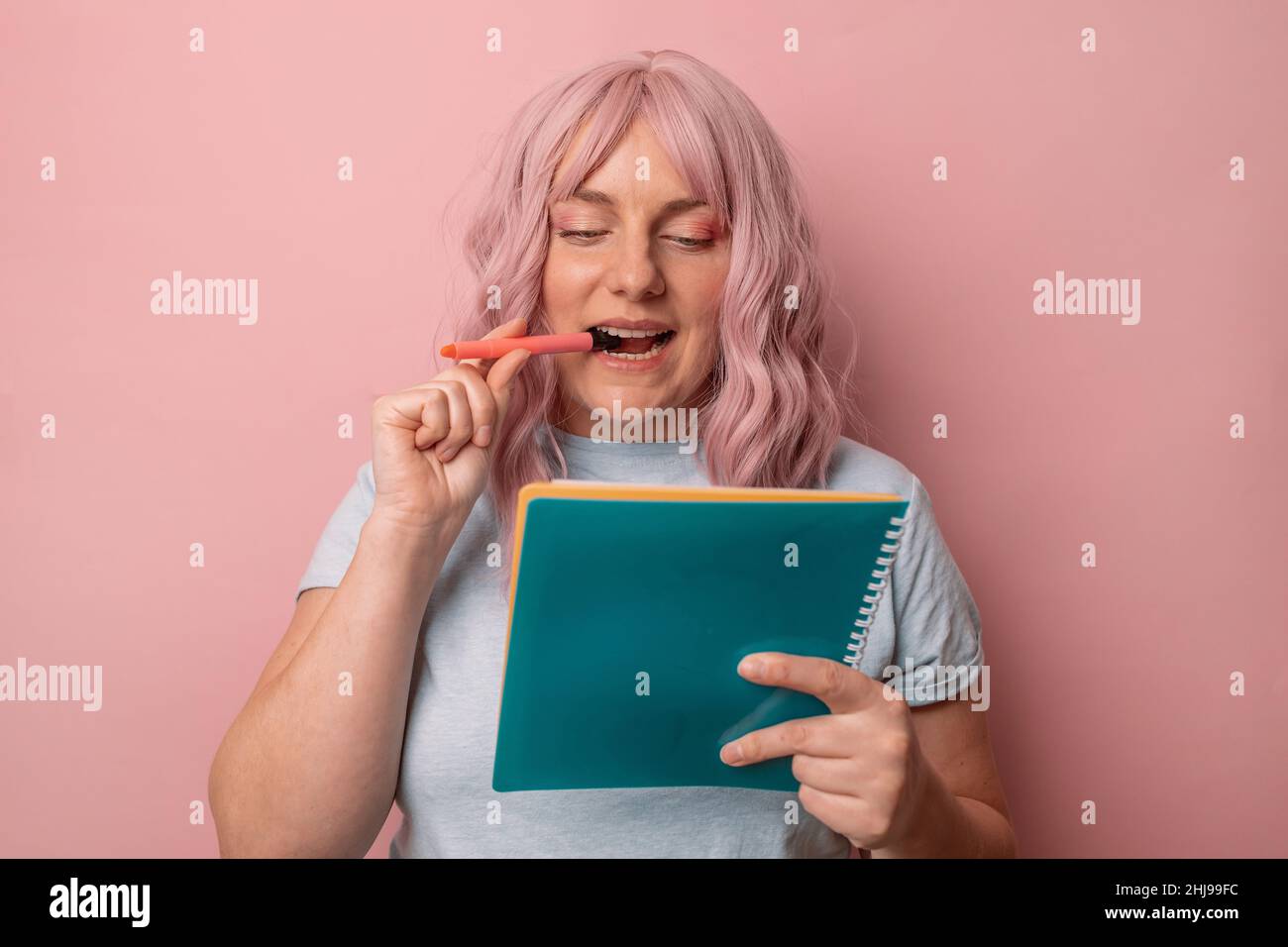 Attractive cheerful woman holding hand pencil, thinking, dreaming ...