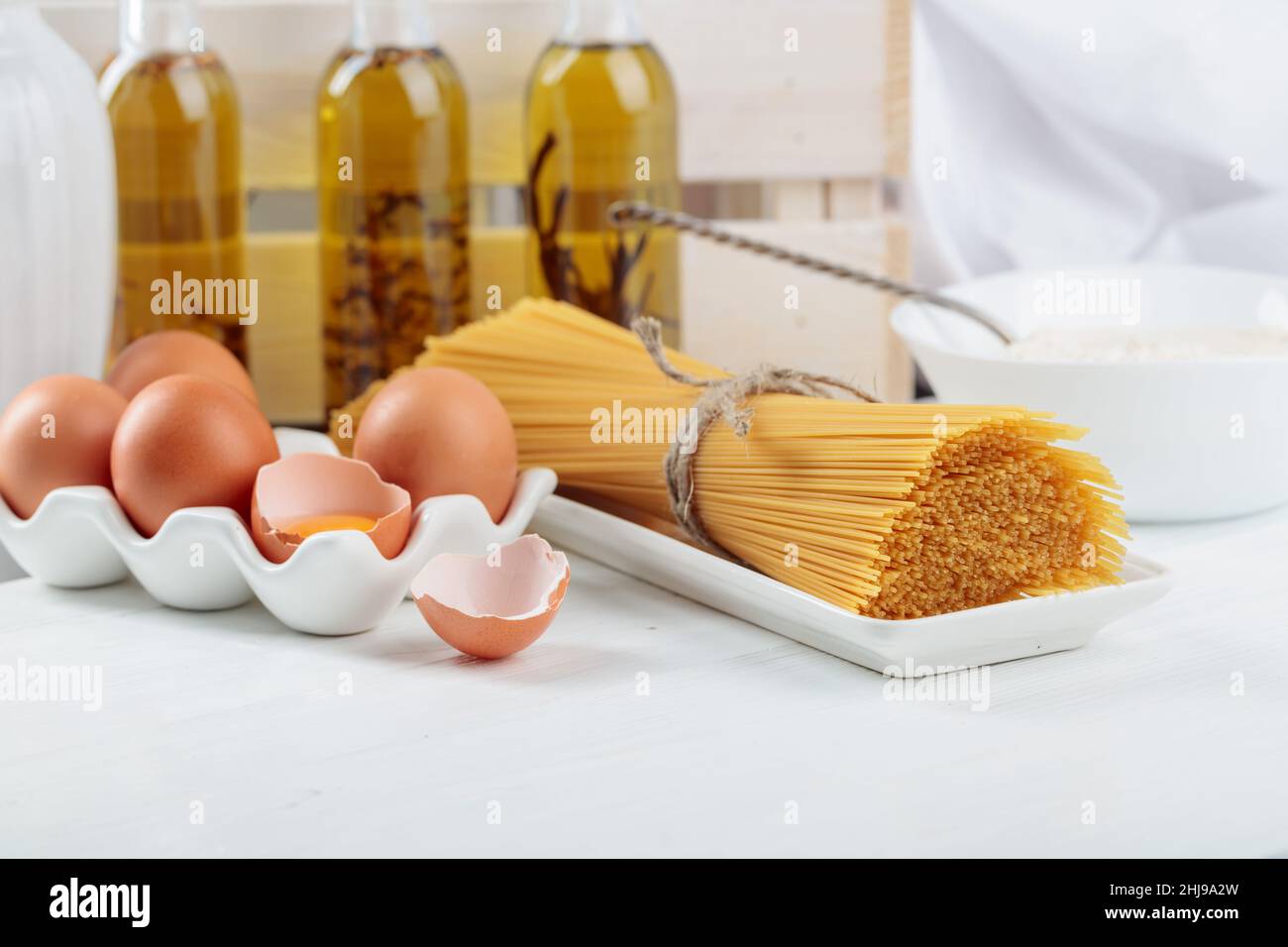 Spaghetti with ingredients on a white wooden table Stock Photo - Alamy