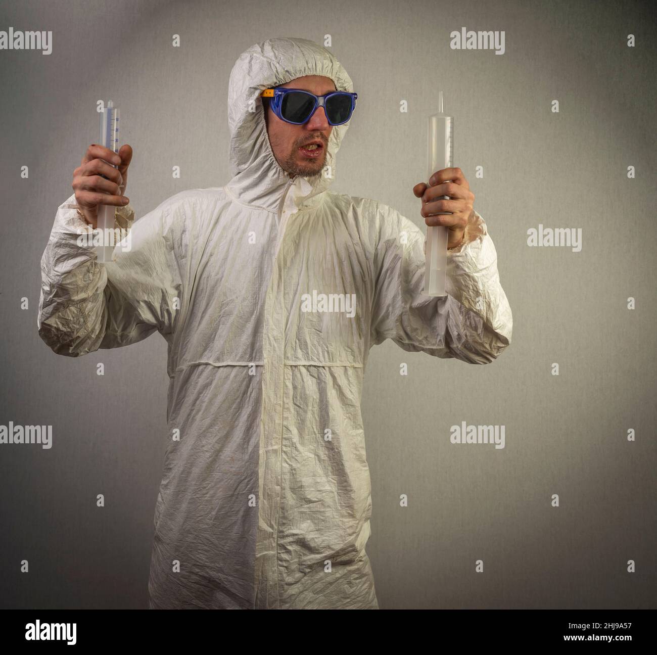 Man with white protection suit and big shot injection with white gray ...