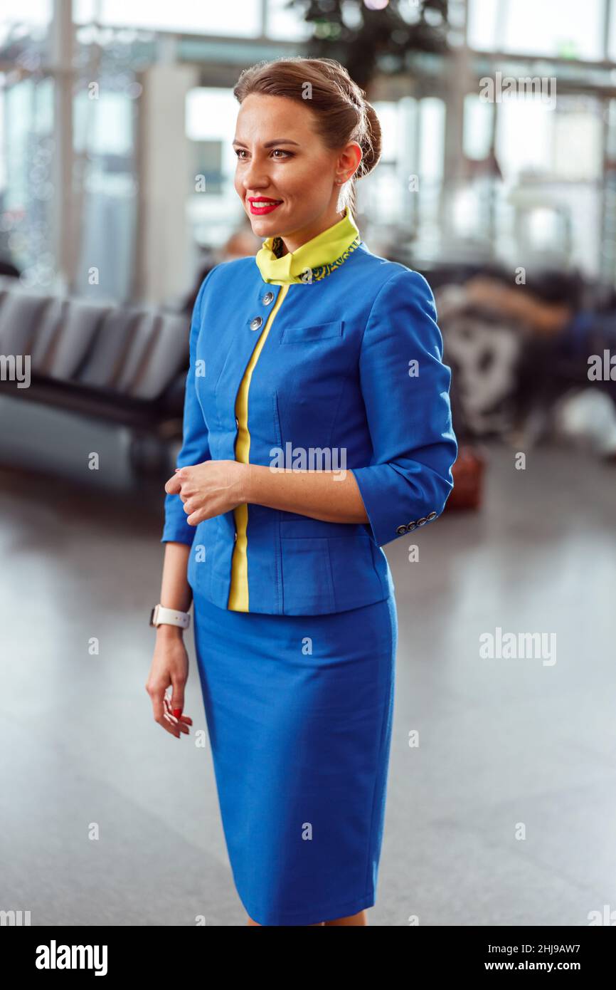 Joyful woman flight attendant standing in airport terminal Stock Photo ...