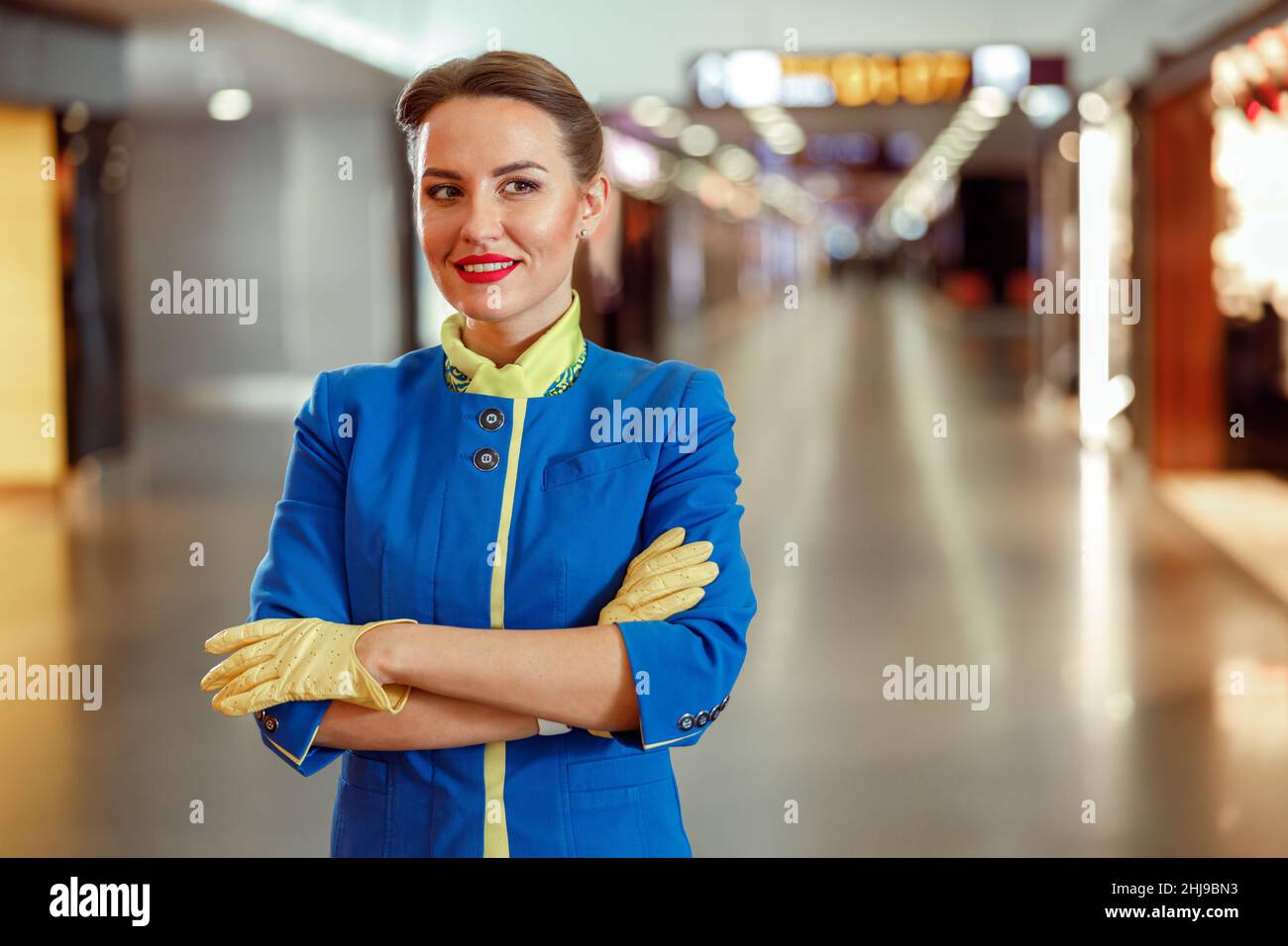 Joyful woman flight attendant standing in airport terminal Stock Photo ...