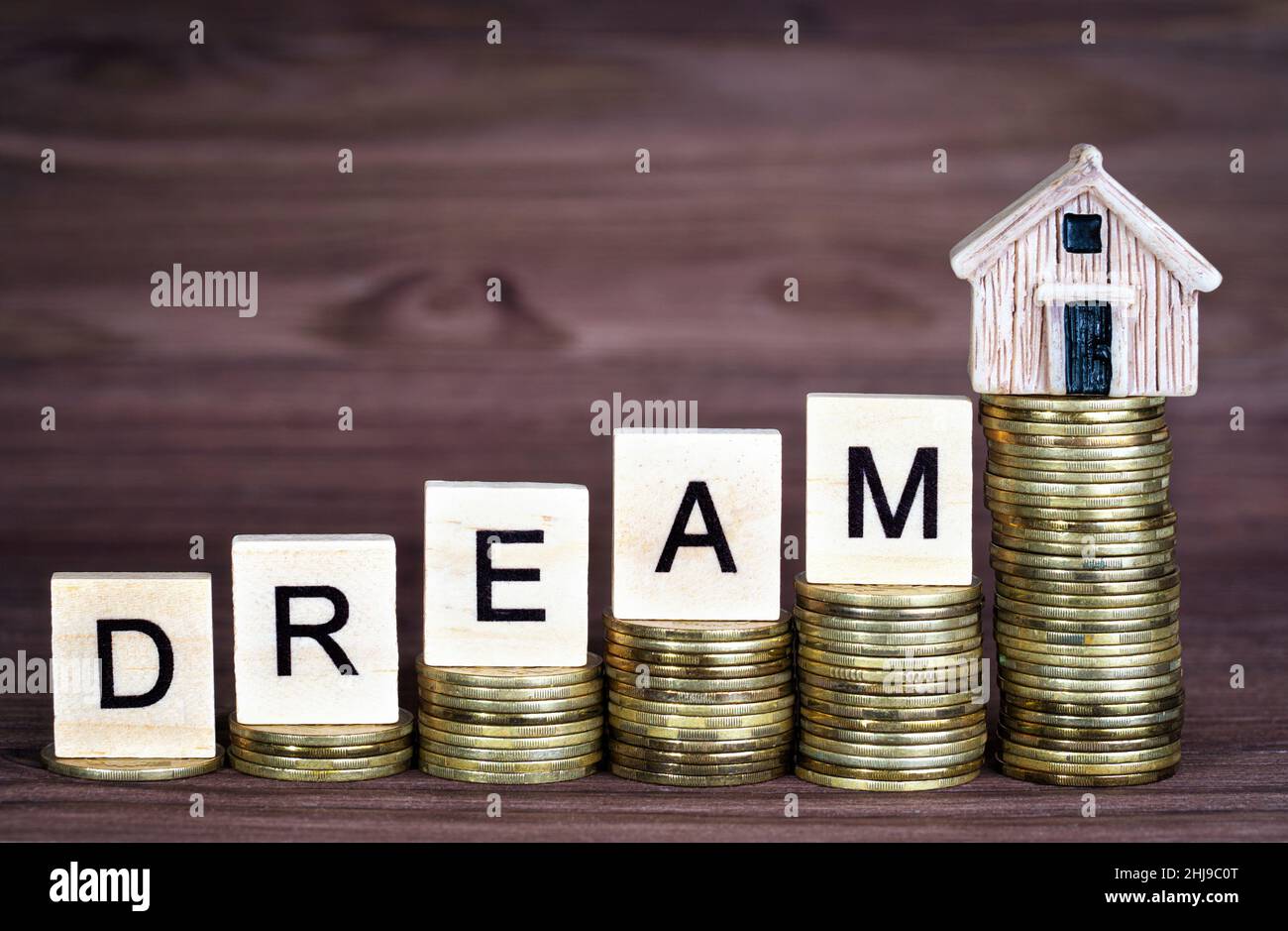 Word DREAM made from wooden letter blocks and a tiny toy house placed ...
