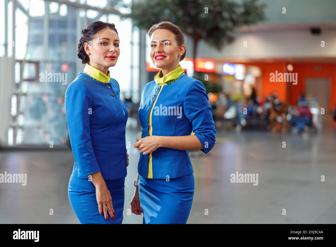 Two female flight attendants standing in airport terminal Stock Photo ...