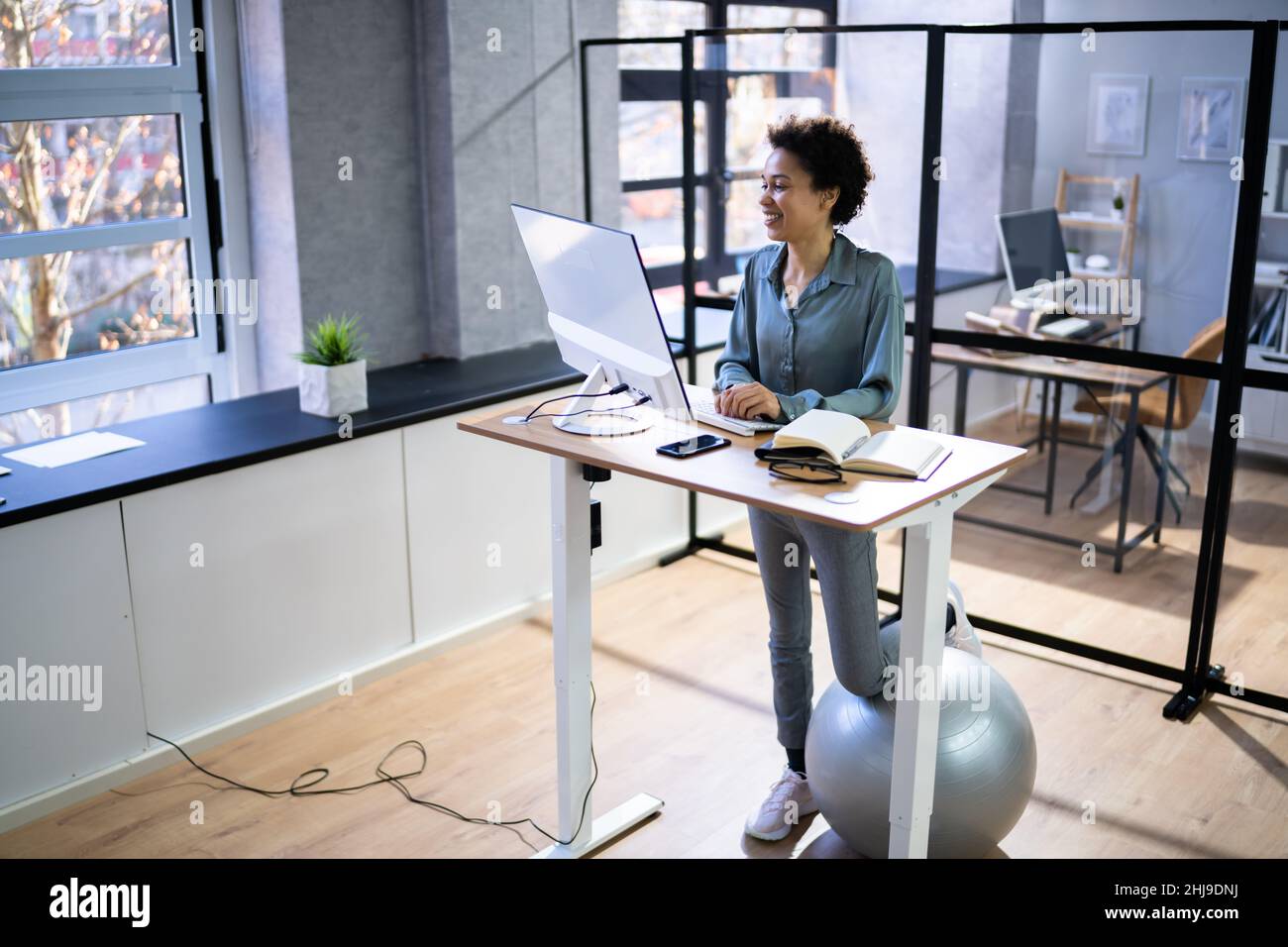 Adjustable Height Desk Stand In Office Using Computer Stock Photo - Alamy