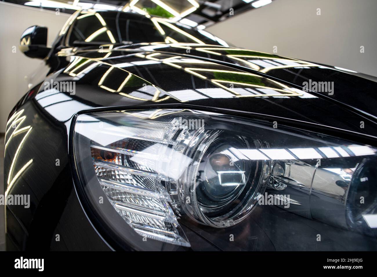 Head lights of a black, big, aggressive car , with neon reflections ...