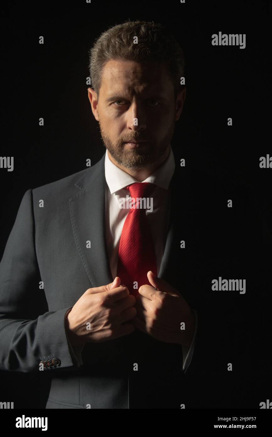 Studio portrait of serious businessman wearing suit and tie and looking ...