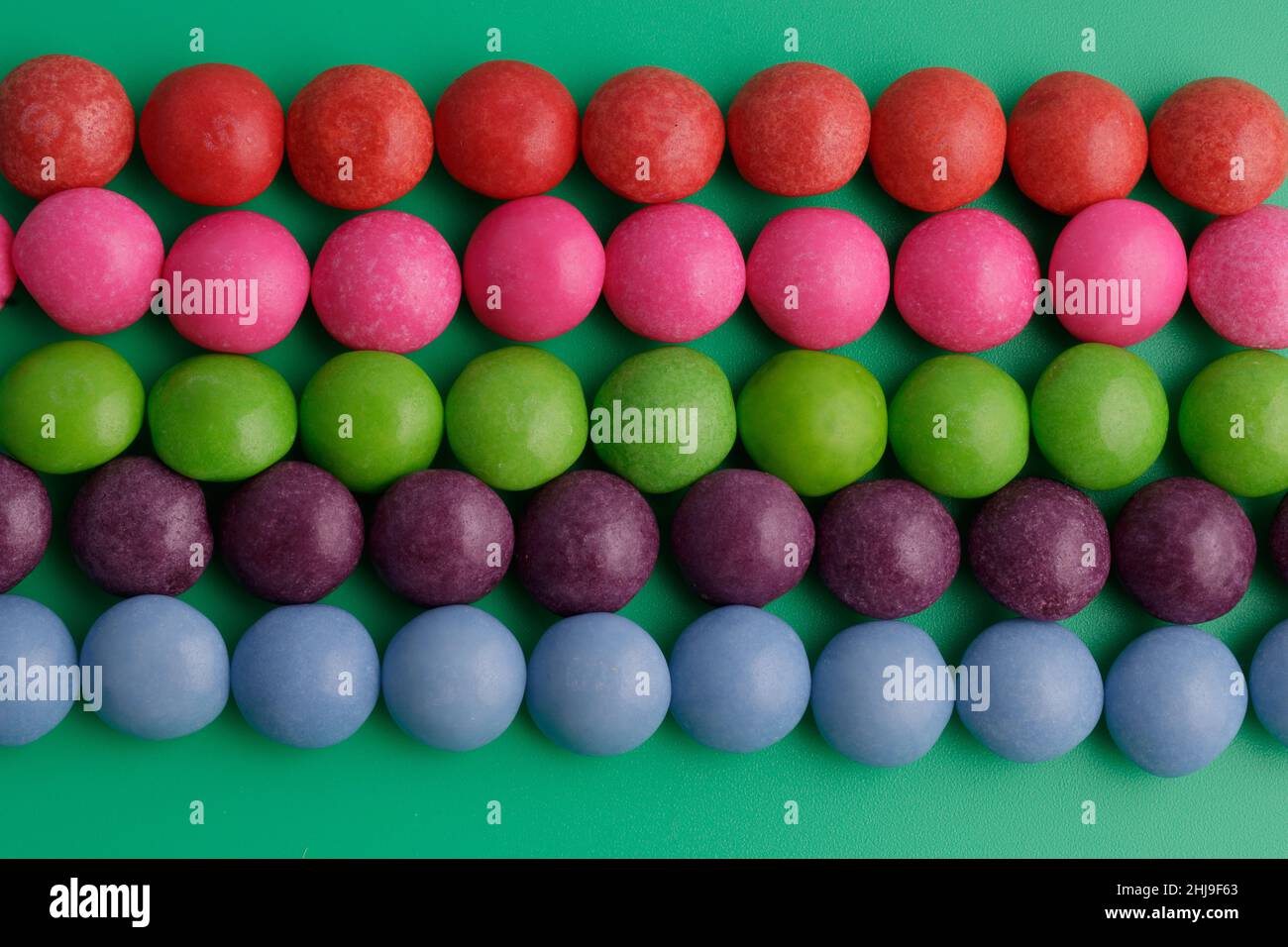 Colorful candy dragees, balls, similar to beads, arranged in lines ...