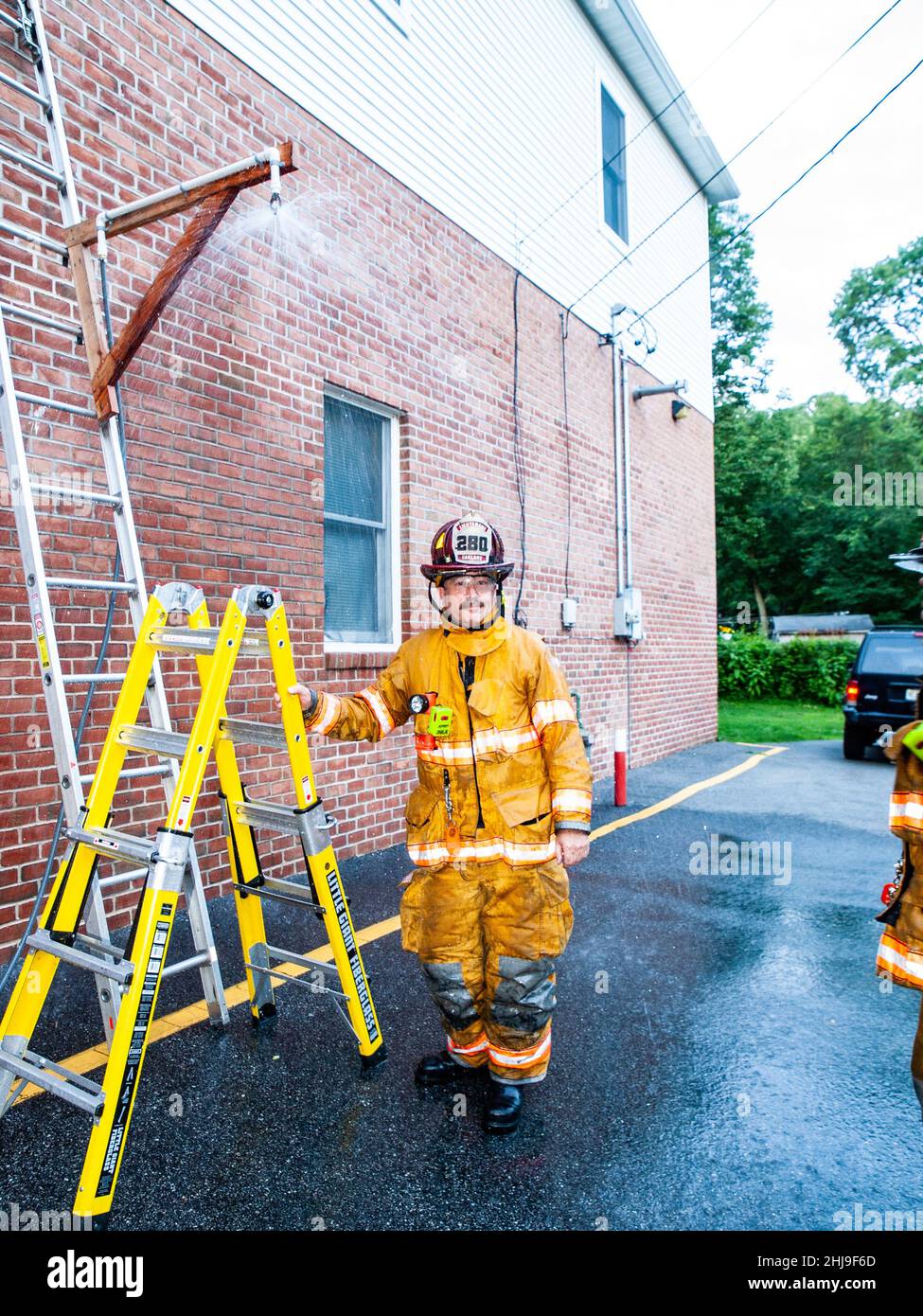 Firefighters drill on sprinkler system in turnout gear Stock Photo - Alamy
