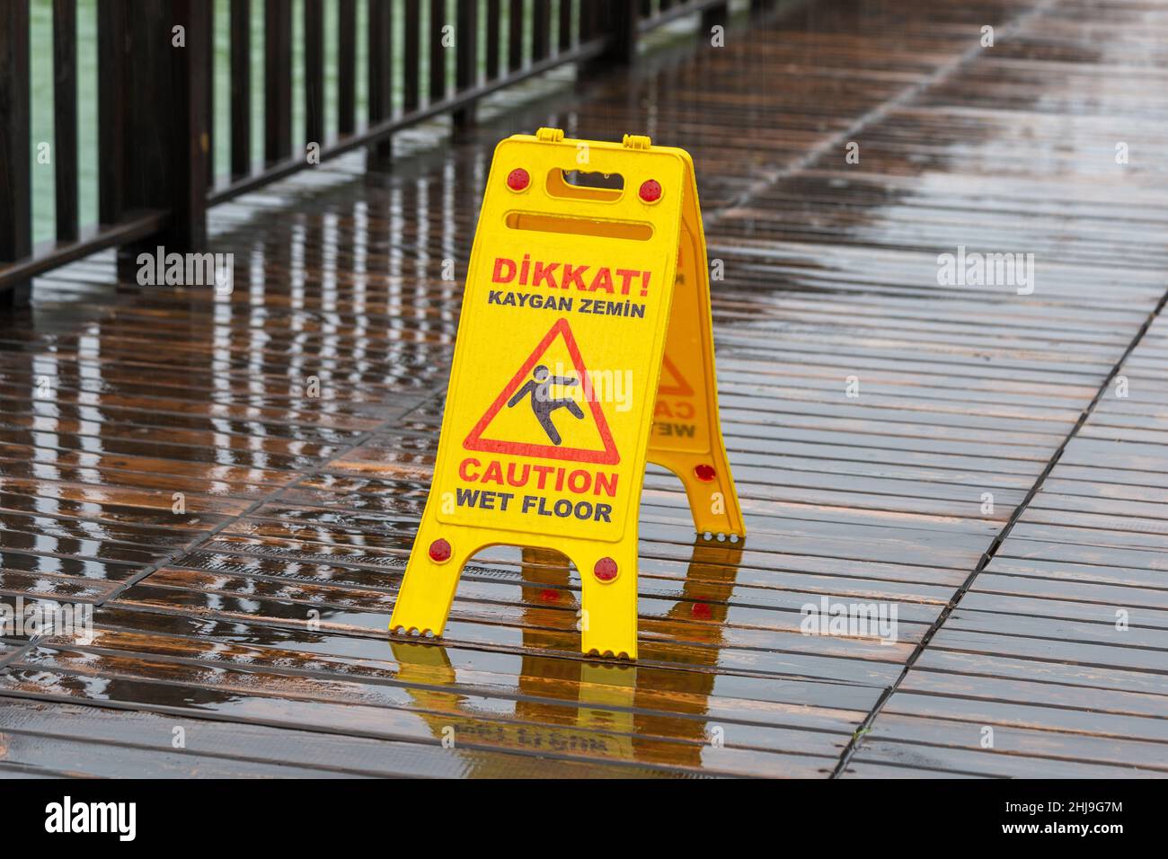 Yellow caution slippery floor sign Stock Photo - Alamy