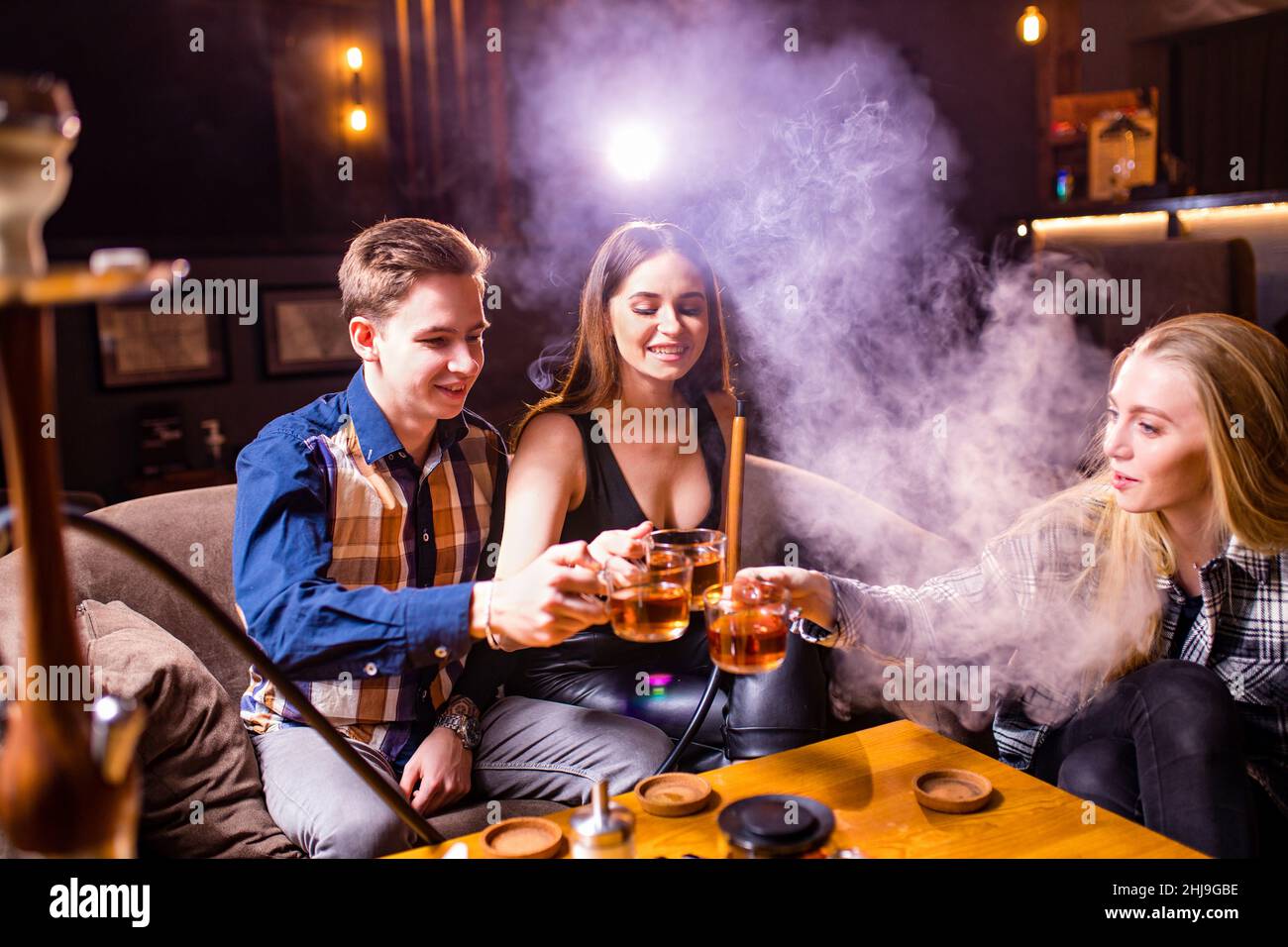Friends party in hookah lounge smoking shisha night time Stock Photo ...