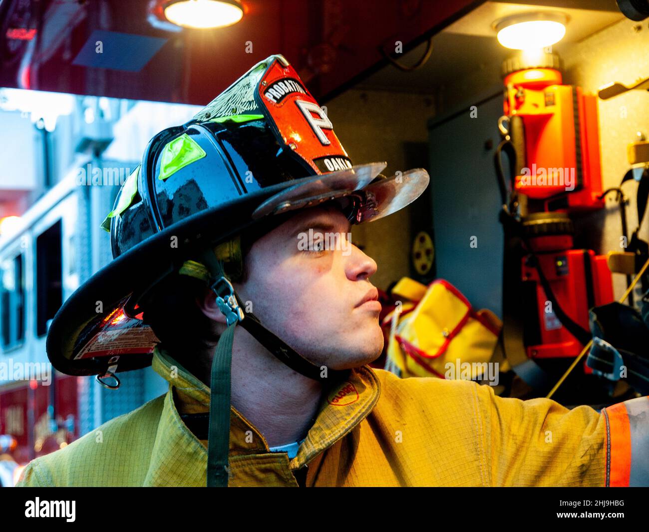 Firefighter checks truck in turnout gear Stock Photo - Alamy