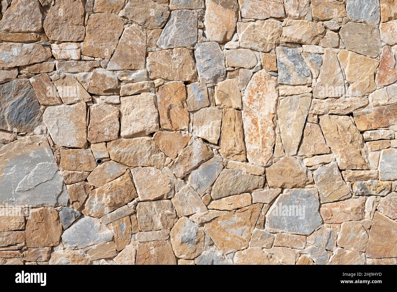 Randomly arranged stone wall background Stock Photo - Alamy