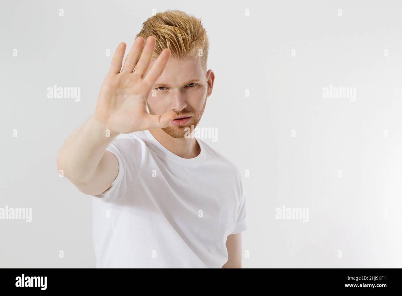 Stop hands sign. Young man in blank template white t shirt showing stop ...