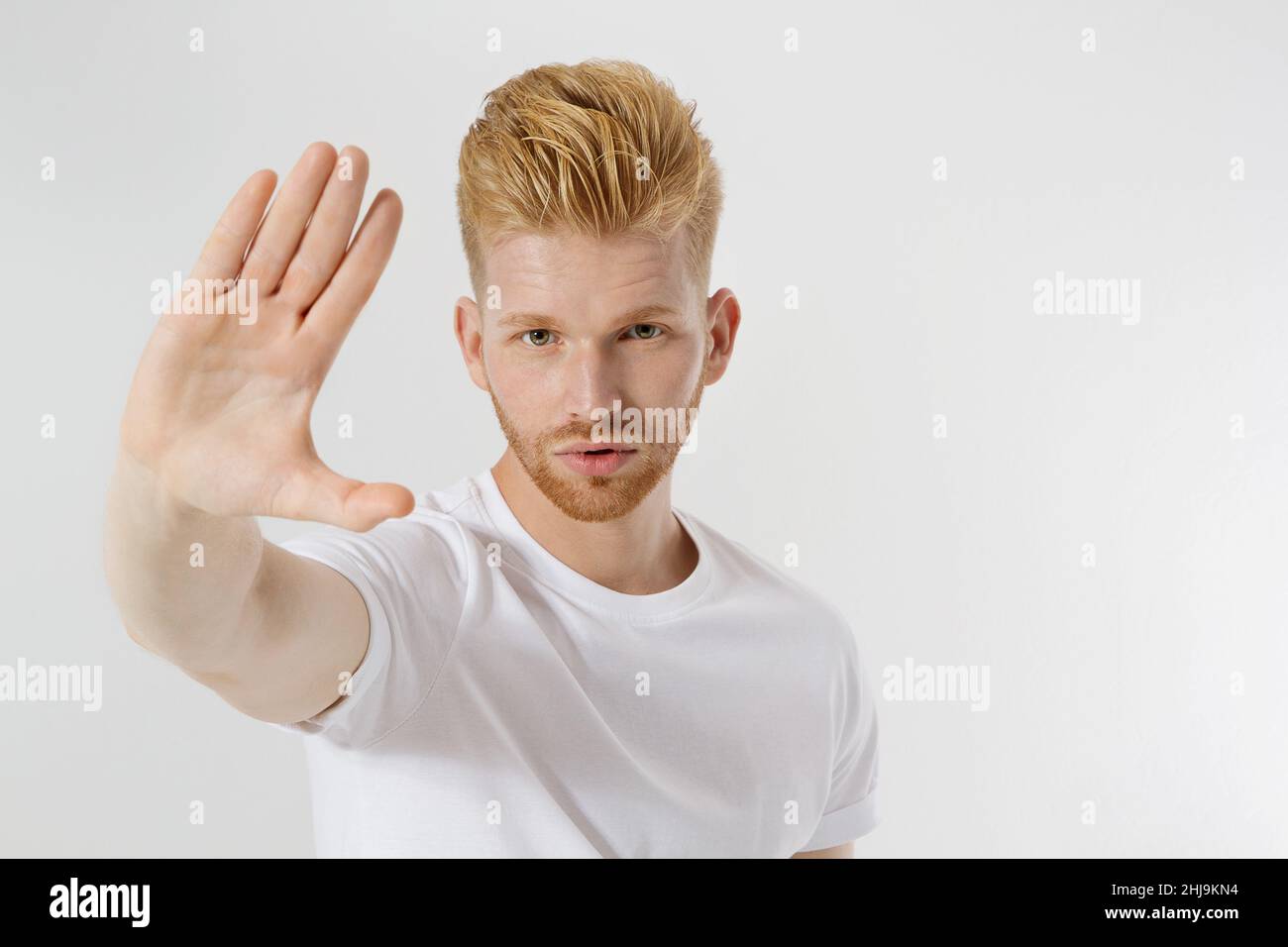 Stop hands sign. Young man in blank template white t shirt showing stop ...