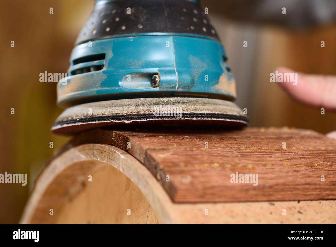 Carpenter grinding merbau wood shell for handmade drum closeup Stock ...