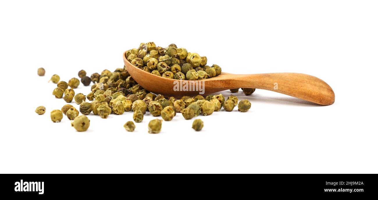 Close up one wooden scoop spoon full of green pepper peppercorns and ...