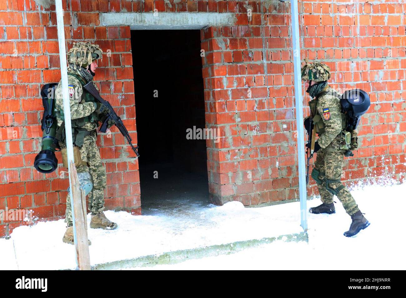 Ukraine. 27th Jan, 2022. Two Ukrainian troops enter a building carrying ...