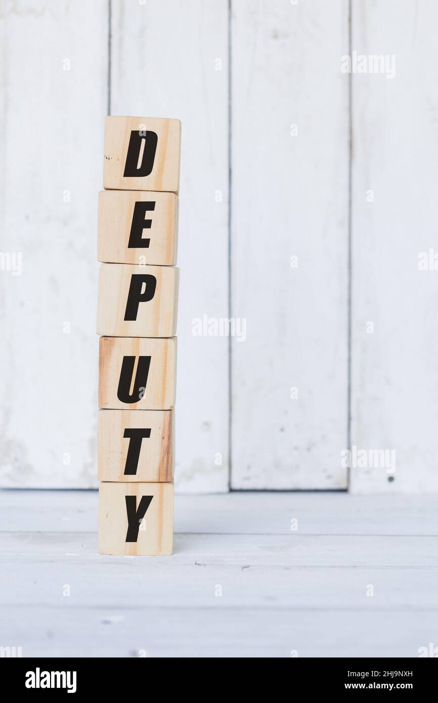 wooden cube, with the word deputy, with white wooden background Stock ...