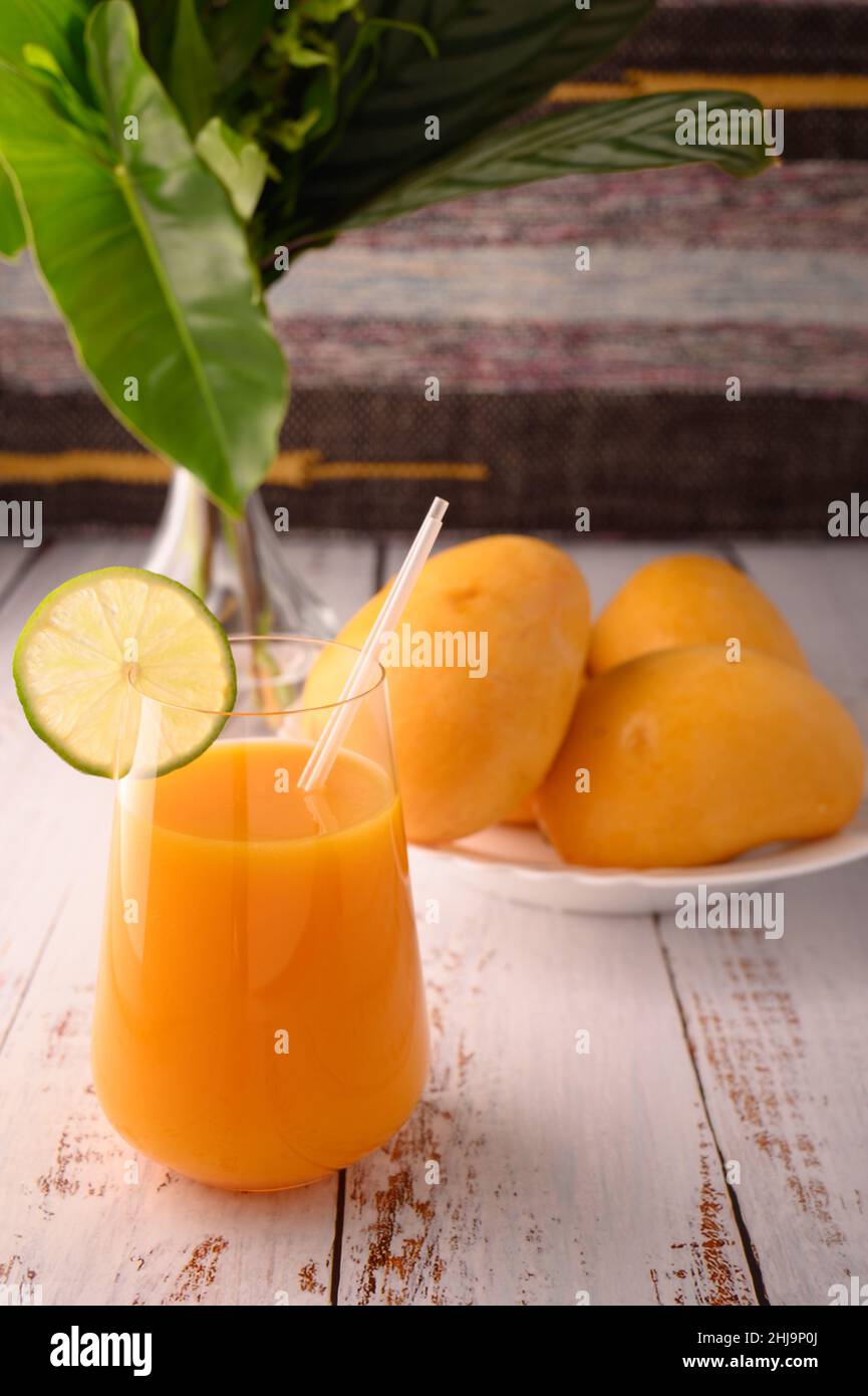 Photo shows glass transparent with natural mango juice. In background ...