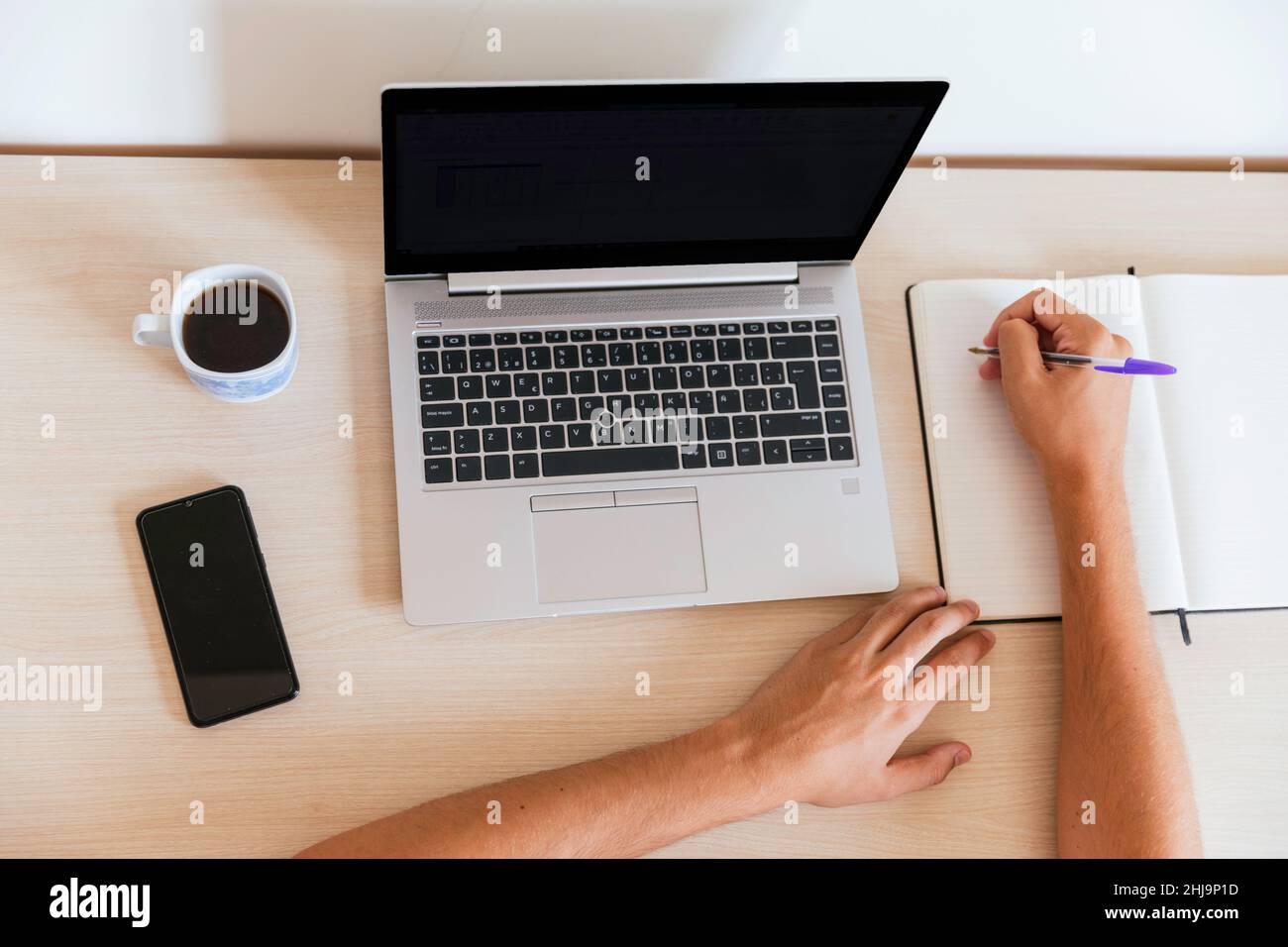View from above of a workspace with computer with black screen, hands ...