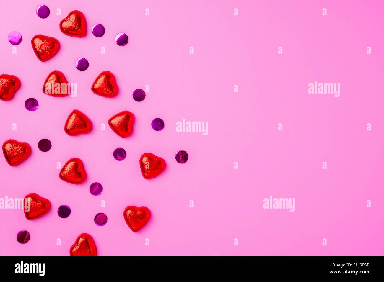 Festive elegant Pink background with shiny candies in the shape of ...