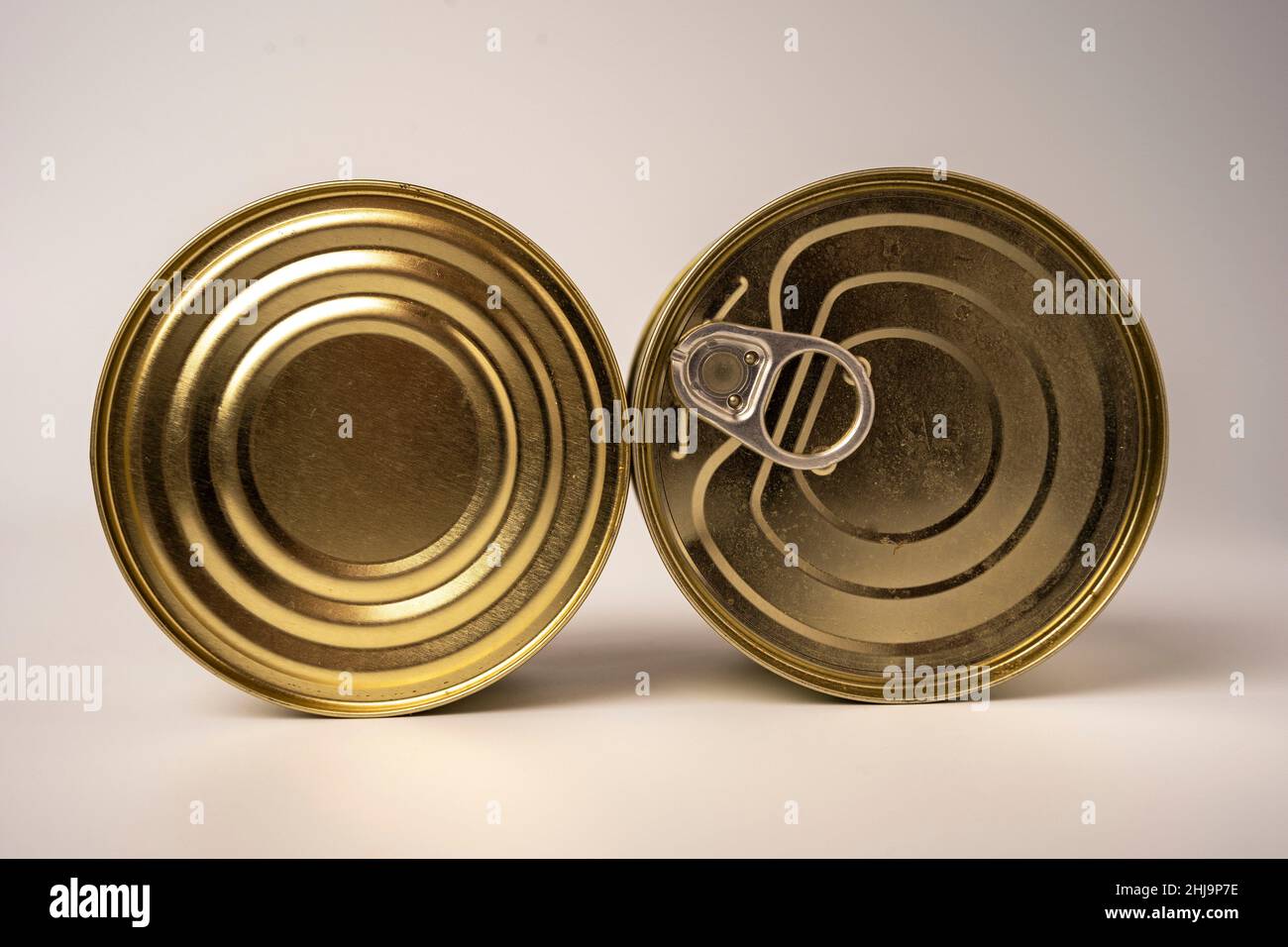 Two shiny tin cans with canned food on a white background close-up ...
