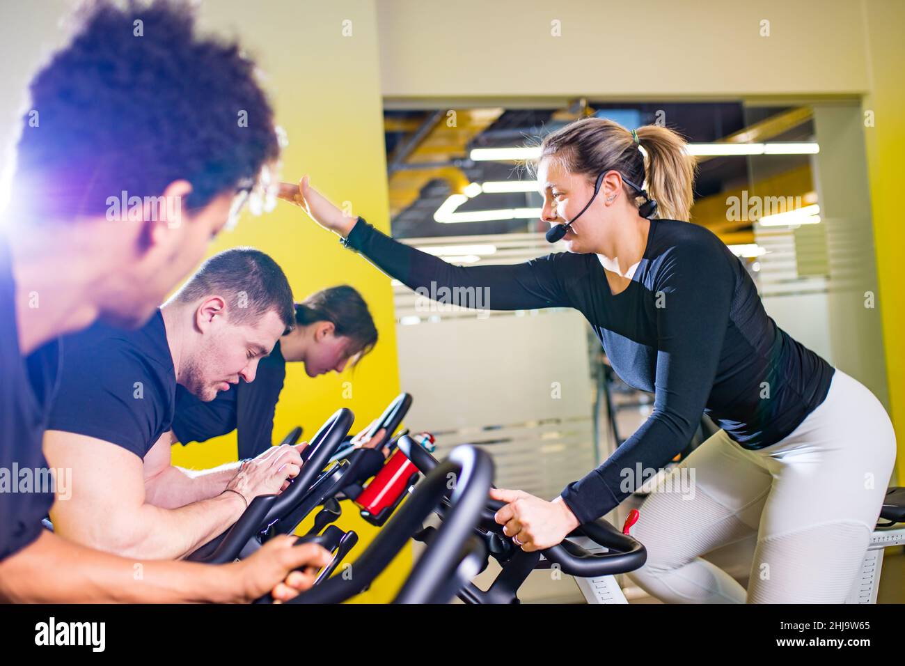 Pretty authentic female instructor with headset in fitness class ...