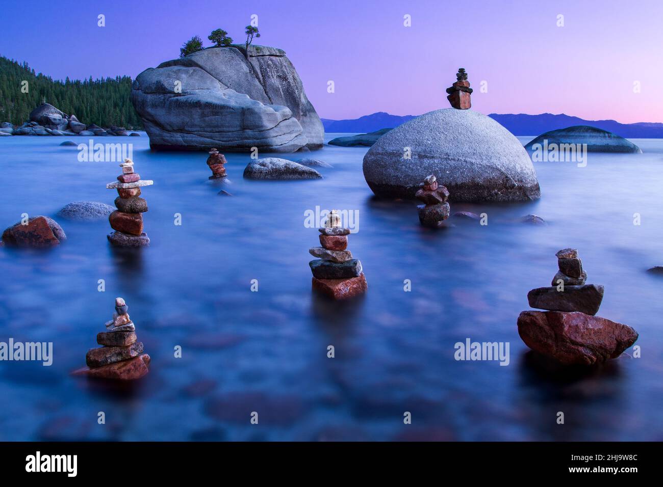 Mystical zen rocks stacked in the sunset reflected water for yoga and ...