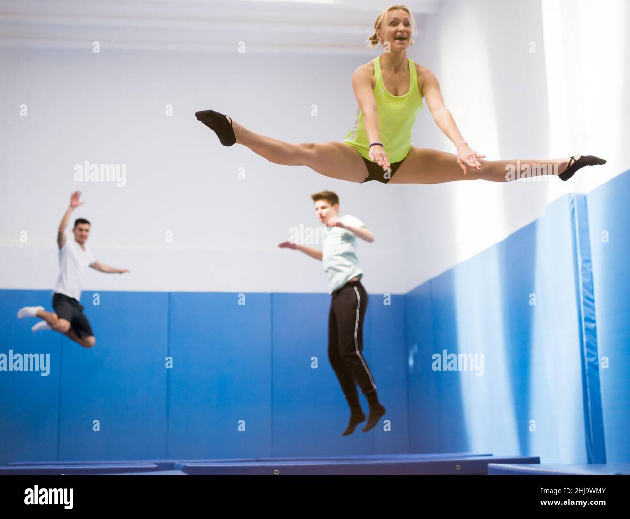 Sports girl training side split on trampoline Stock Photo - Alamy
