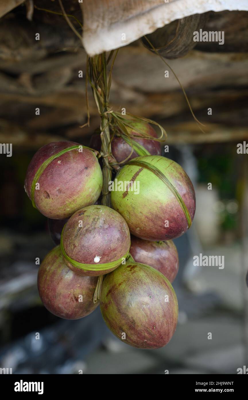 Photo shows several purple tropical fruits. One fruit is cut open and ...