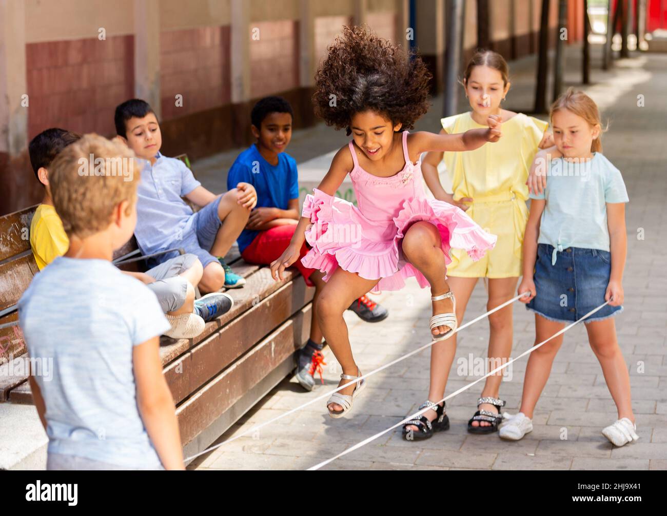 Happy smiling little friends playing with chinese jumping rope Stock ...