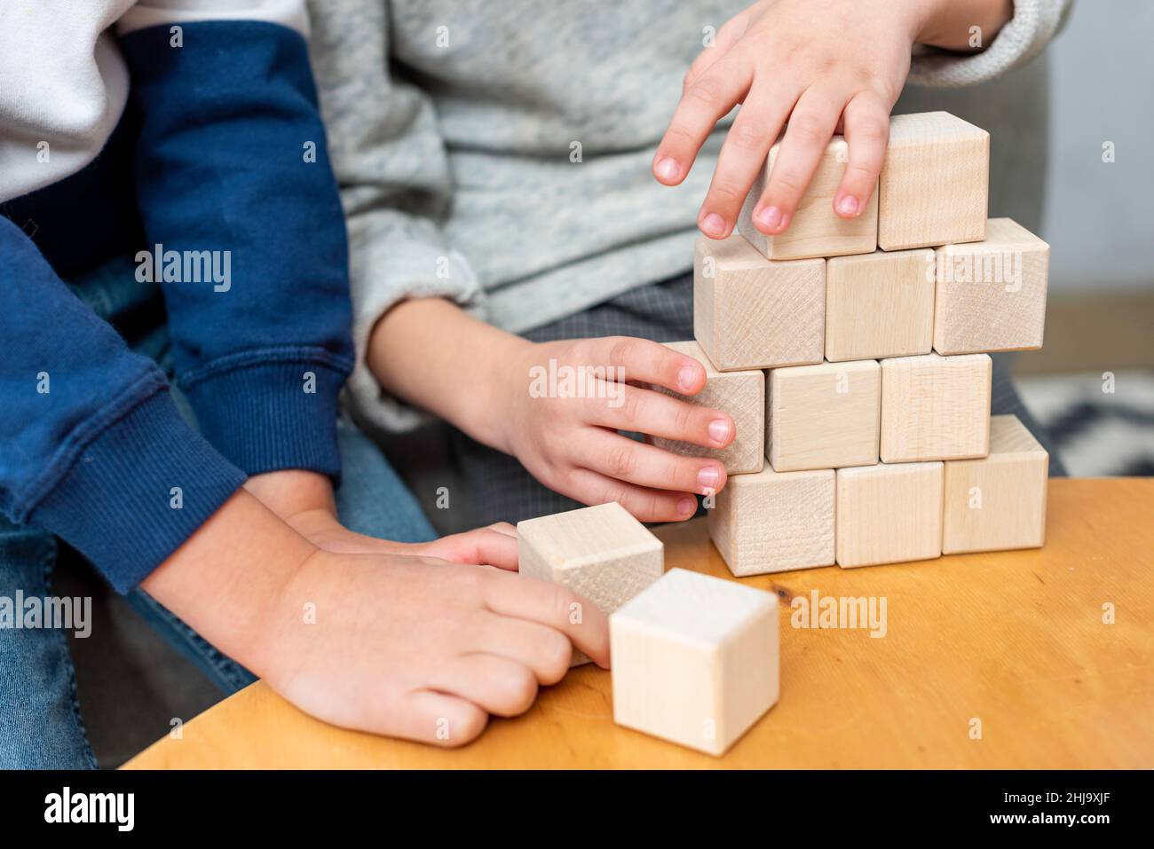 Boys play cubes with each other . Two children of different ages are ...