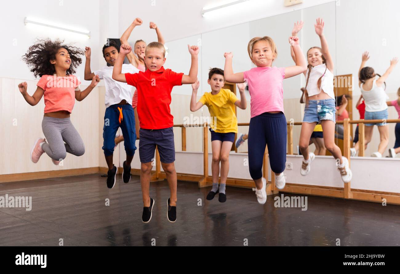 Cheerful tweens jumping with trainer during dance class Stock Photo - Alamy