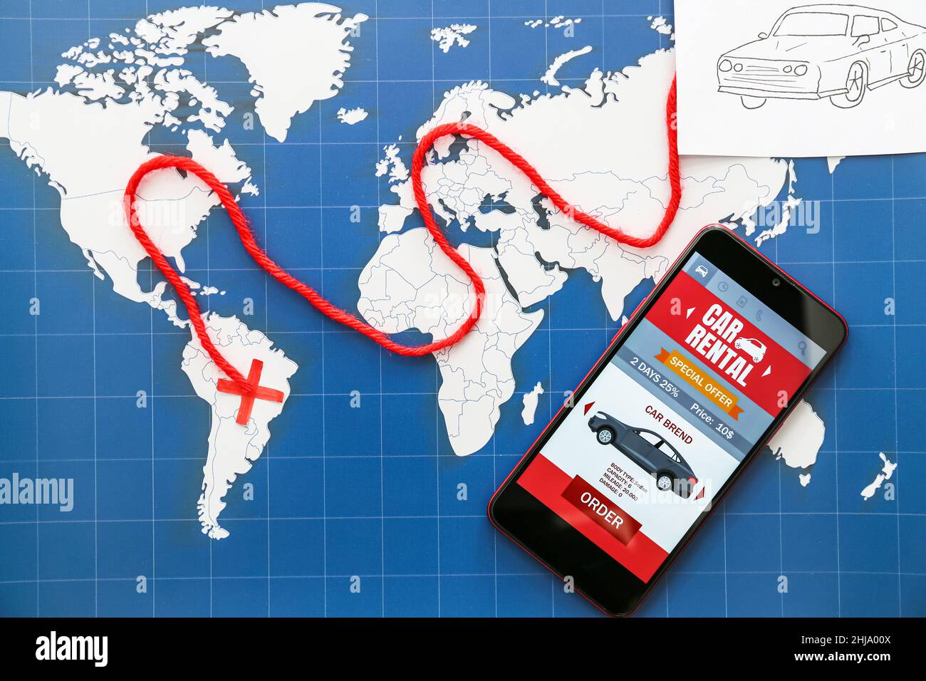 Mobile phone with open car rent app, drawn auto and thread on world map ...