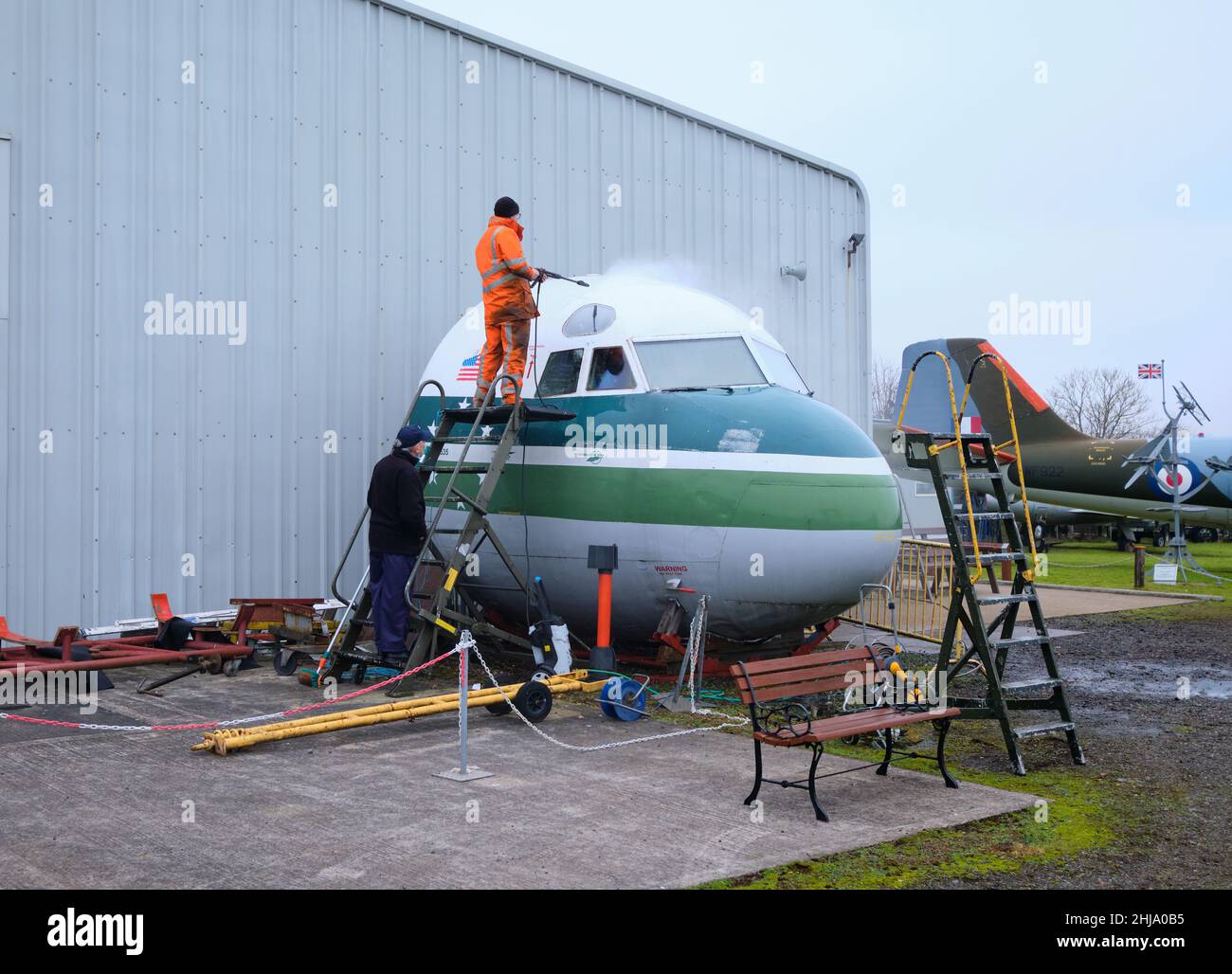 Two men jet washing an aircraft nose section Stock Photo - Alamy