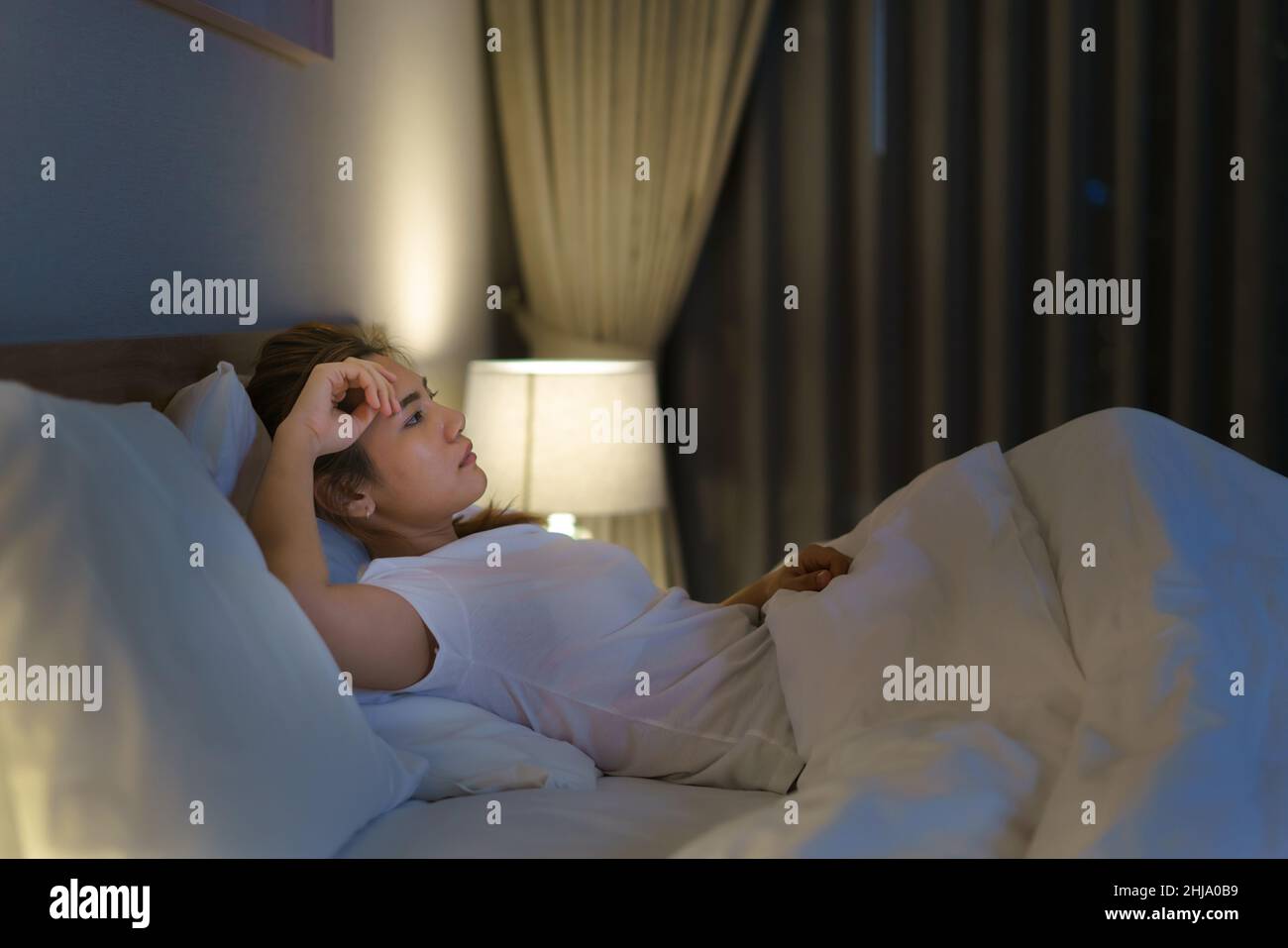 Young woman lying awake in bed worried hi-res stock photography and ...