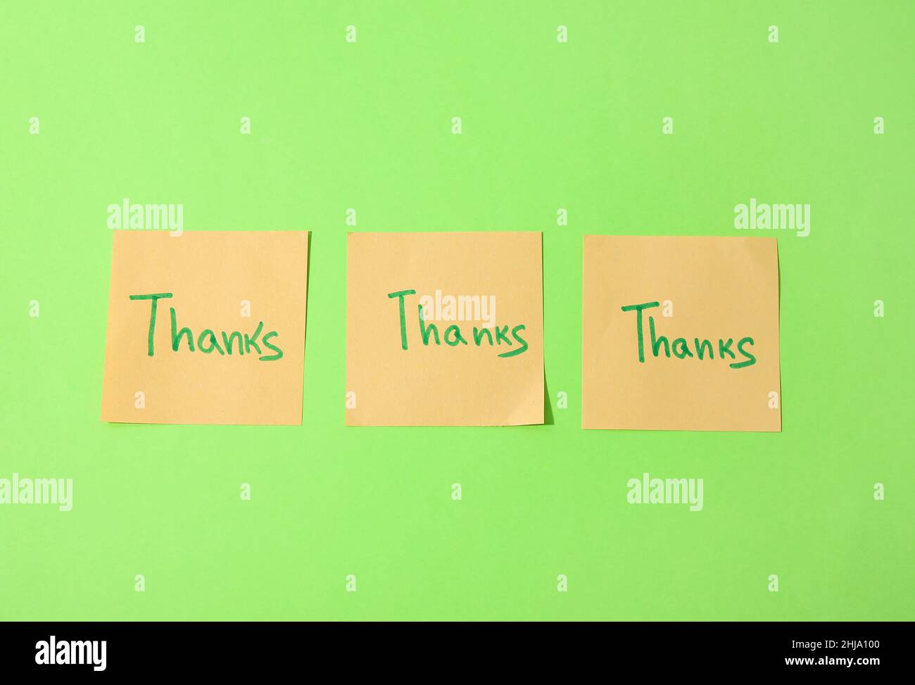 Sticky notes with word THANKS on green background Stock Photo - Alamy