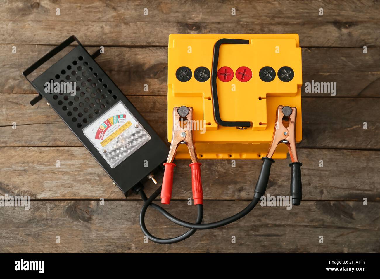 Modern car battery and tester on wooden background Stock Photo - Alamy
