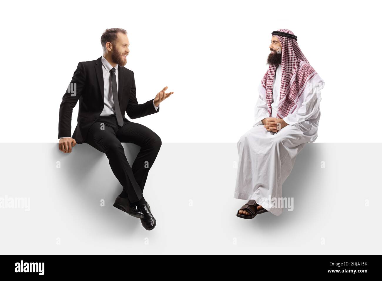 Businessman and a saudi arab man having a conversation seated on a ...