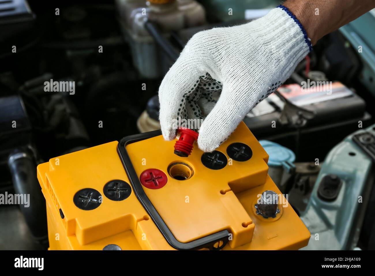 Male mechanic fixing car battery, closeup Stock Photo - Alamy
